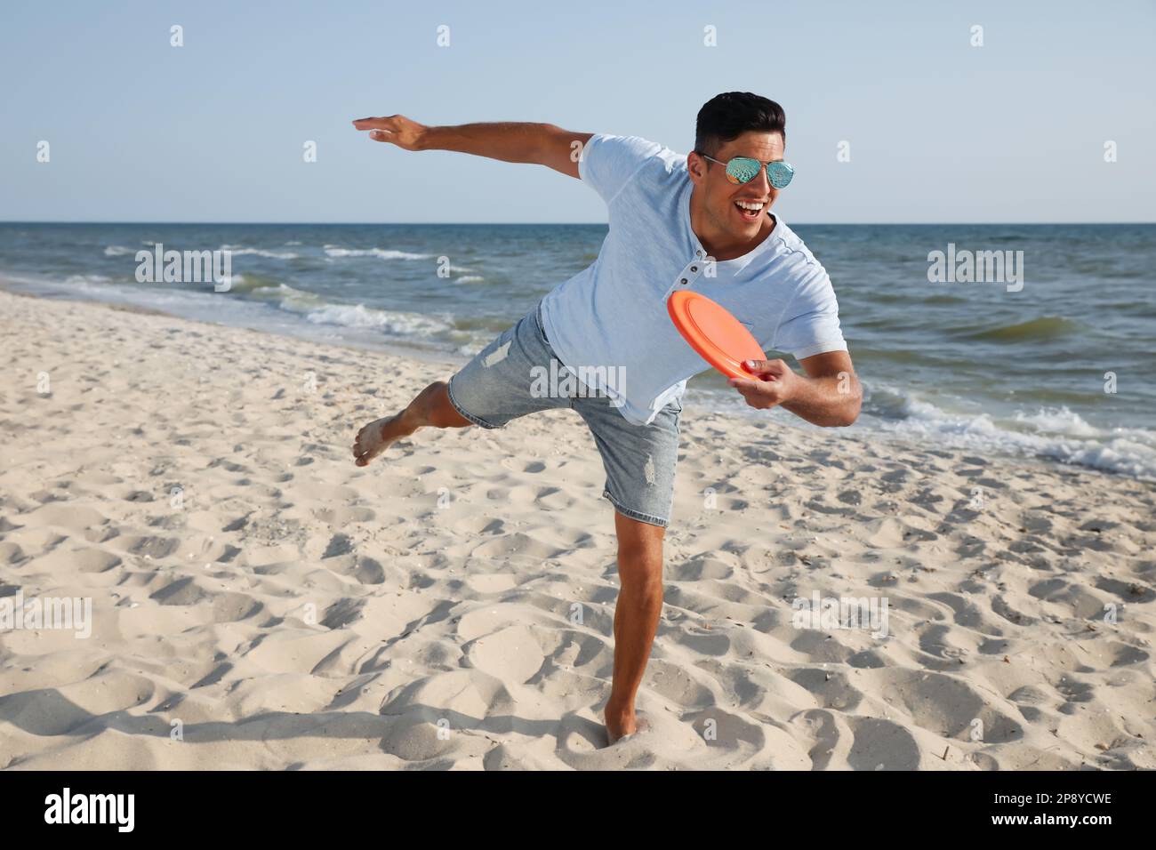 Man throwing frisbee beach hi-res stock photography and images - Alamy