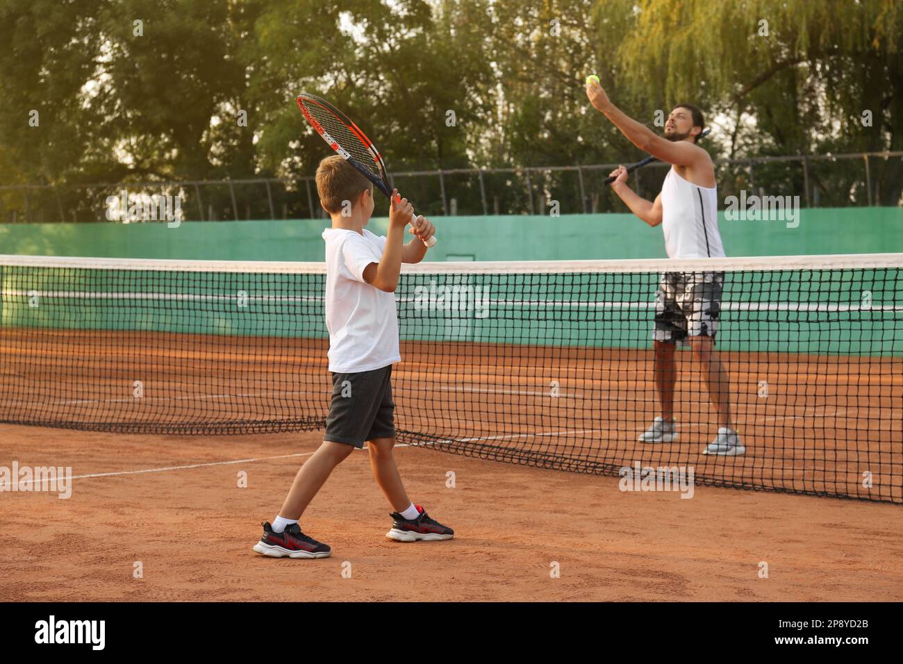 Father with his son playing tennis on court Stock Photo - Alamy