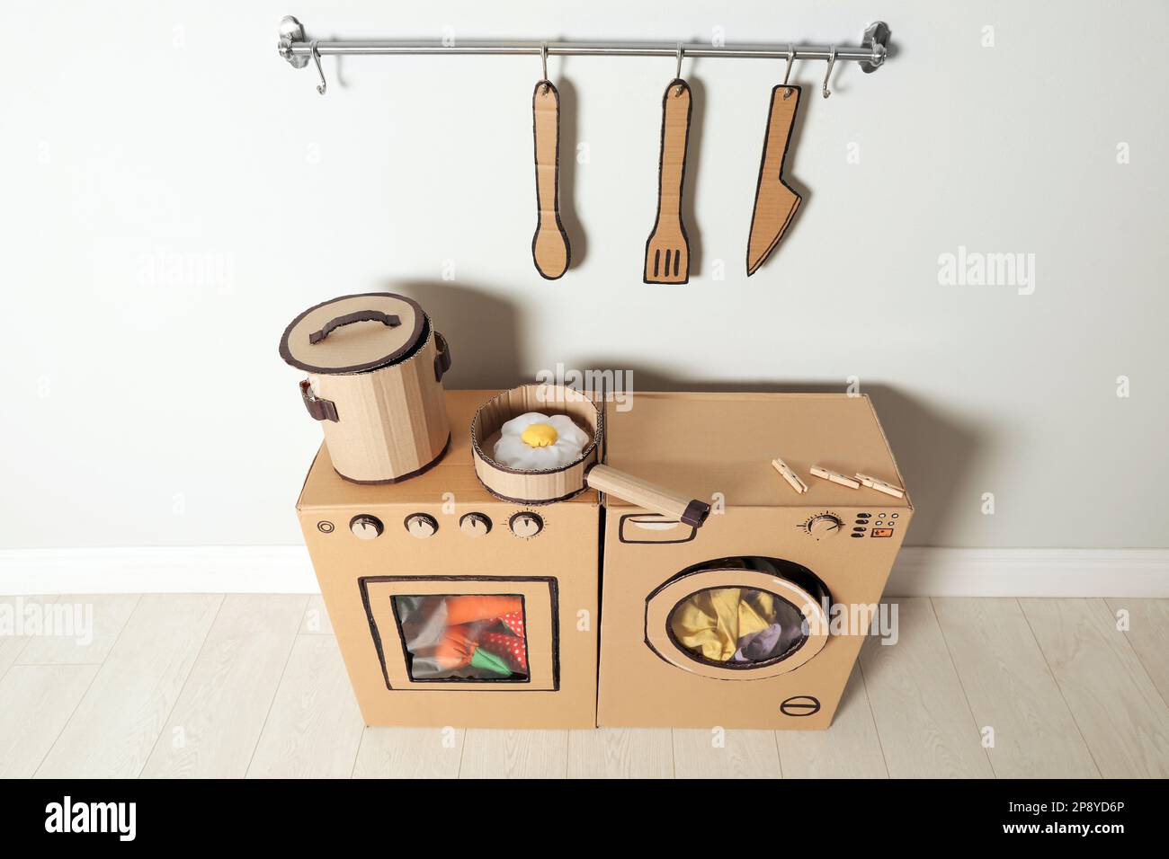Cardboard kitchen and washing machine near white wall indoors Stock ...