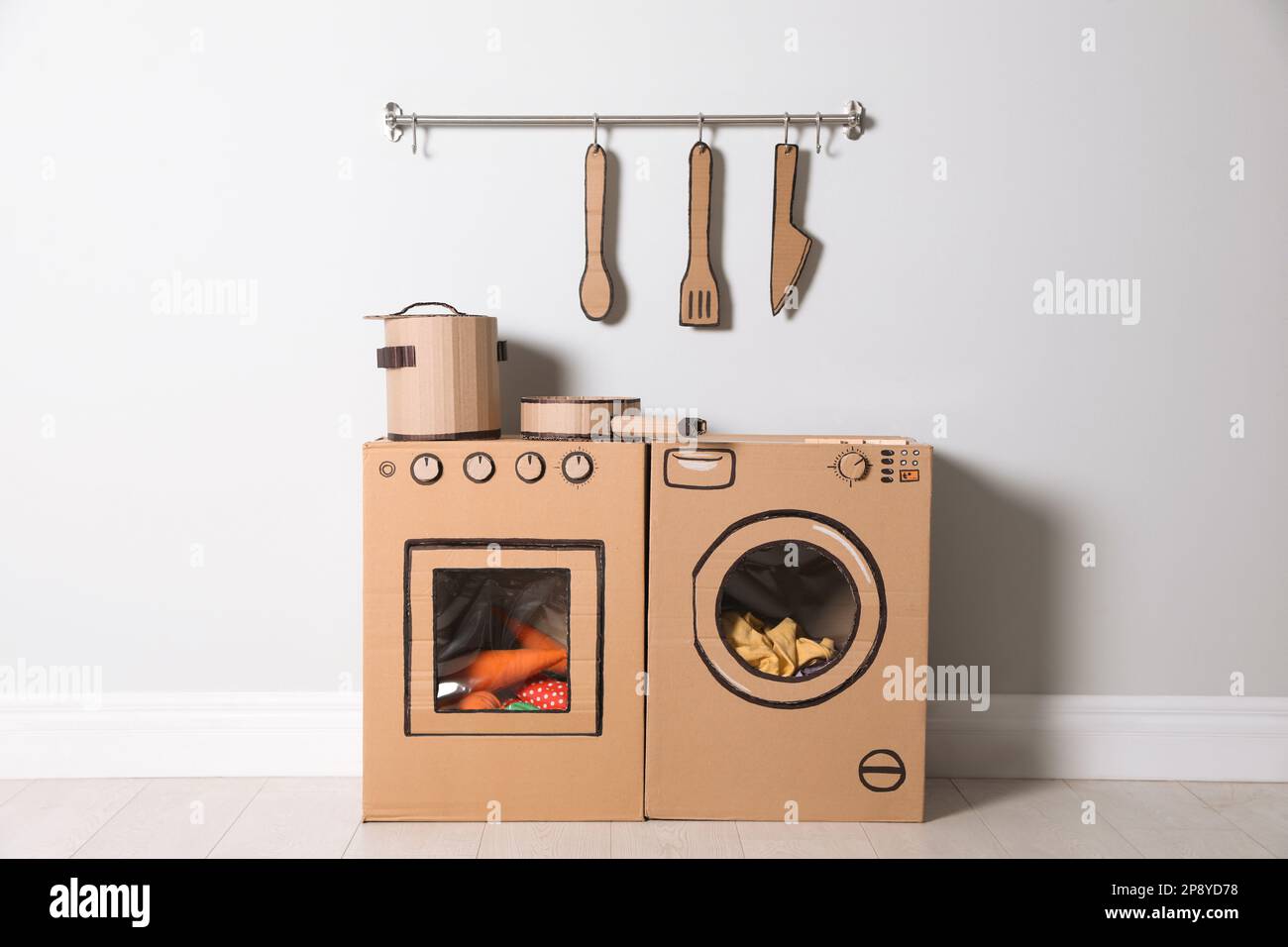 Cardboard kitchen and washing machine near white wall indoors Stock ...
