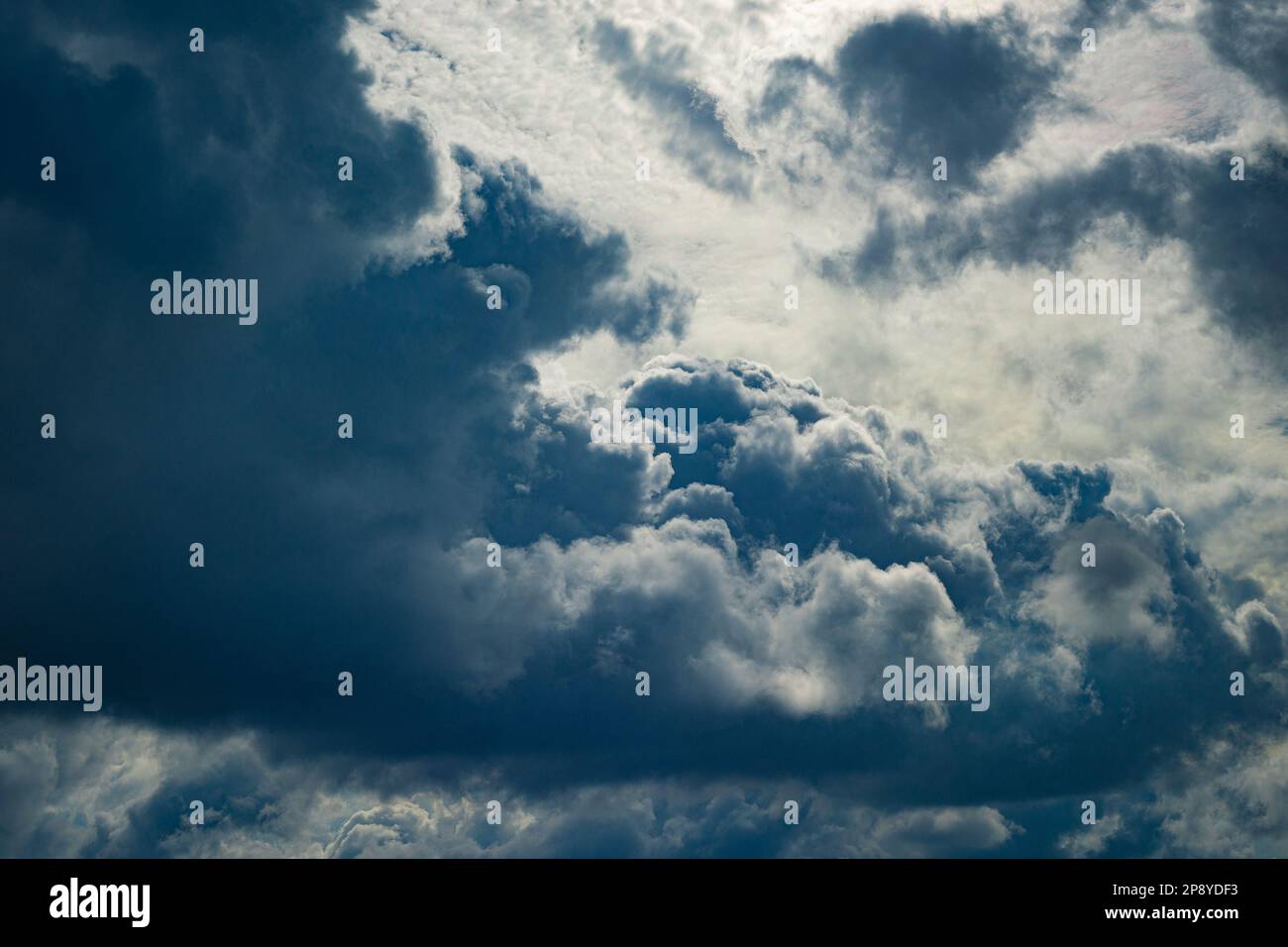 High Contrast Puffy Dark Cloudscape with Sun behind clouds causing ...