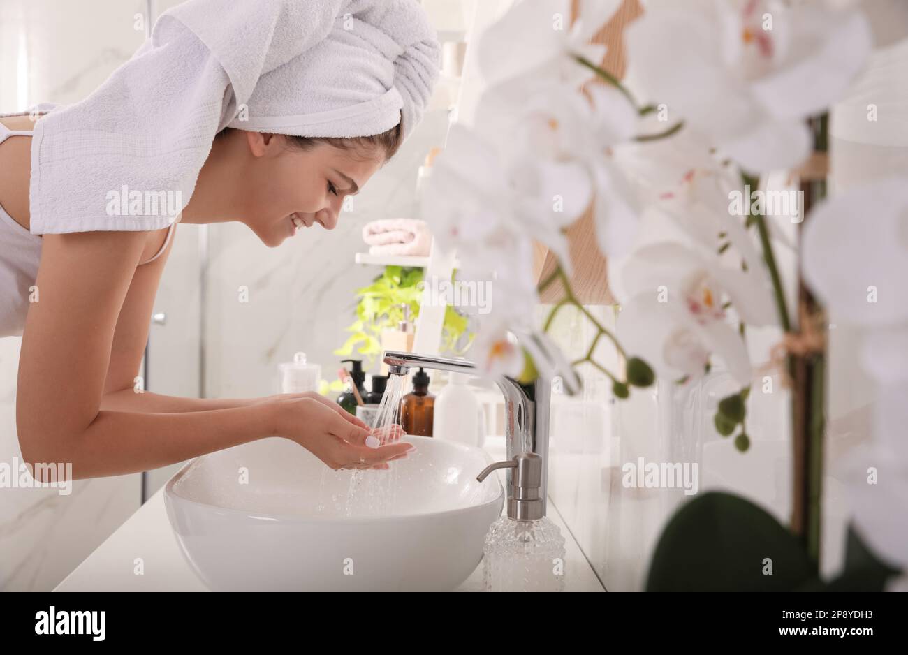 Beautiful teenage girl washing face with water in bathroom Stock Photo ...