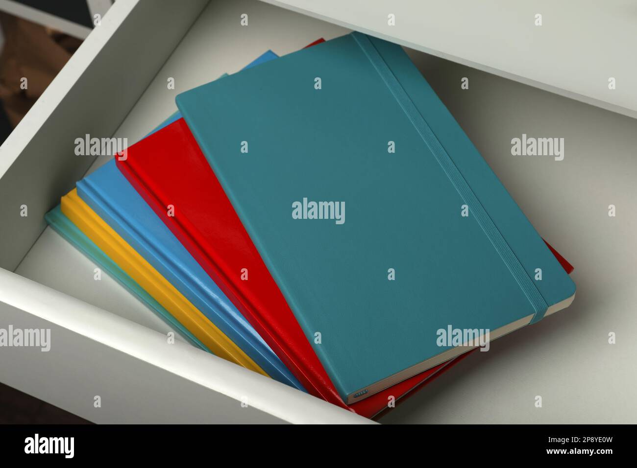Stack of colorful planners in open drawer, closeup Stock Photo - Alamy