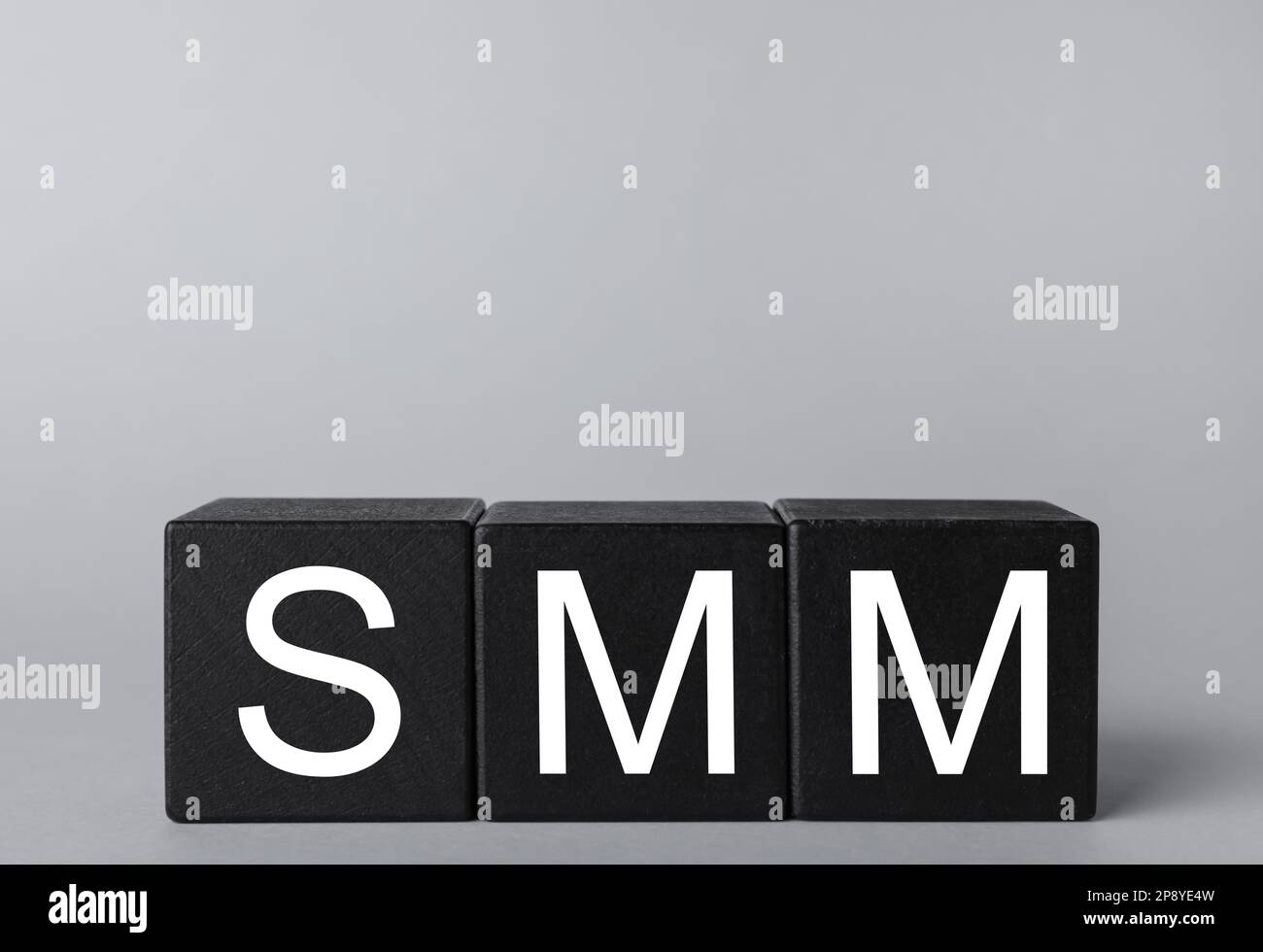 Black cubes with abbreviation SMM (Social media marketing) on grey ...