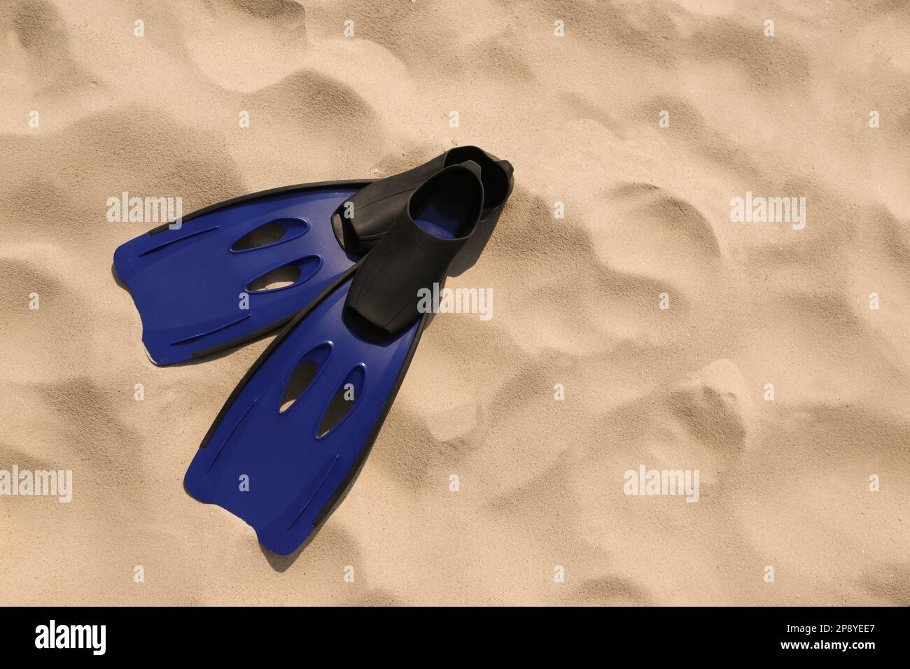 Pair of blue flippers on sand, top view. Space for text Stock Photo - Alamy