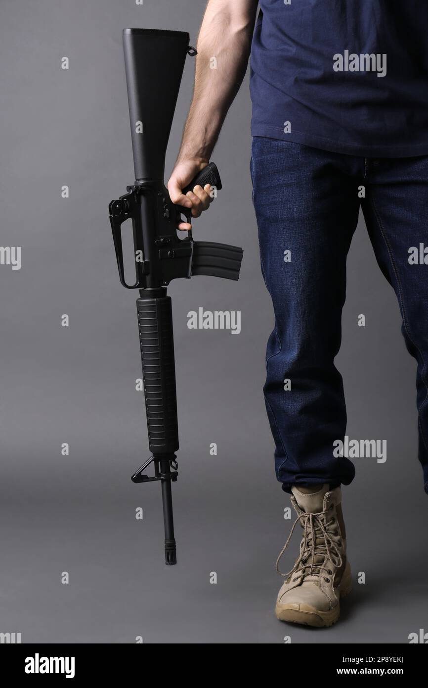 Assault gun. Man holding rifle on dark background, closeup Stock Photo ... Assault gun. Man holding rifle on dark background, closeup Stock Photo ...
