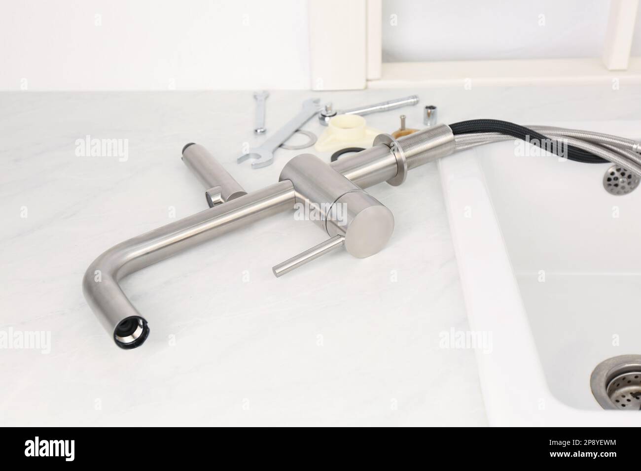 Plumber's tools and water tap ready for installation near sink on ...