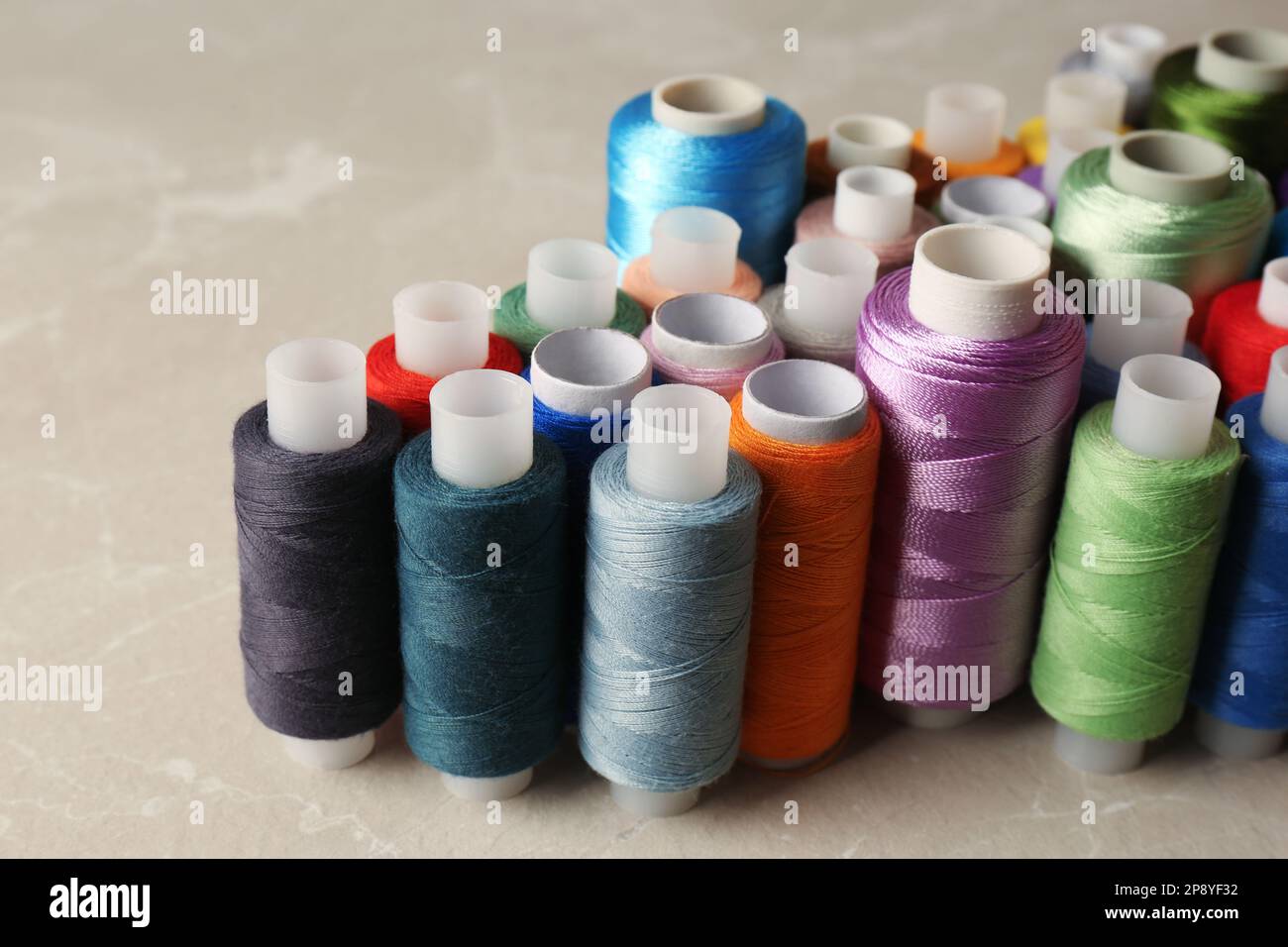 Set of color sewing threads on light grey table Stock Photo - Alamy