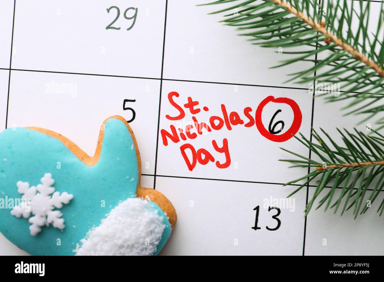 Gingerbread cookie and fir tree branch on calendar page with marked ...