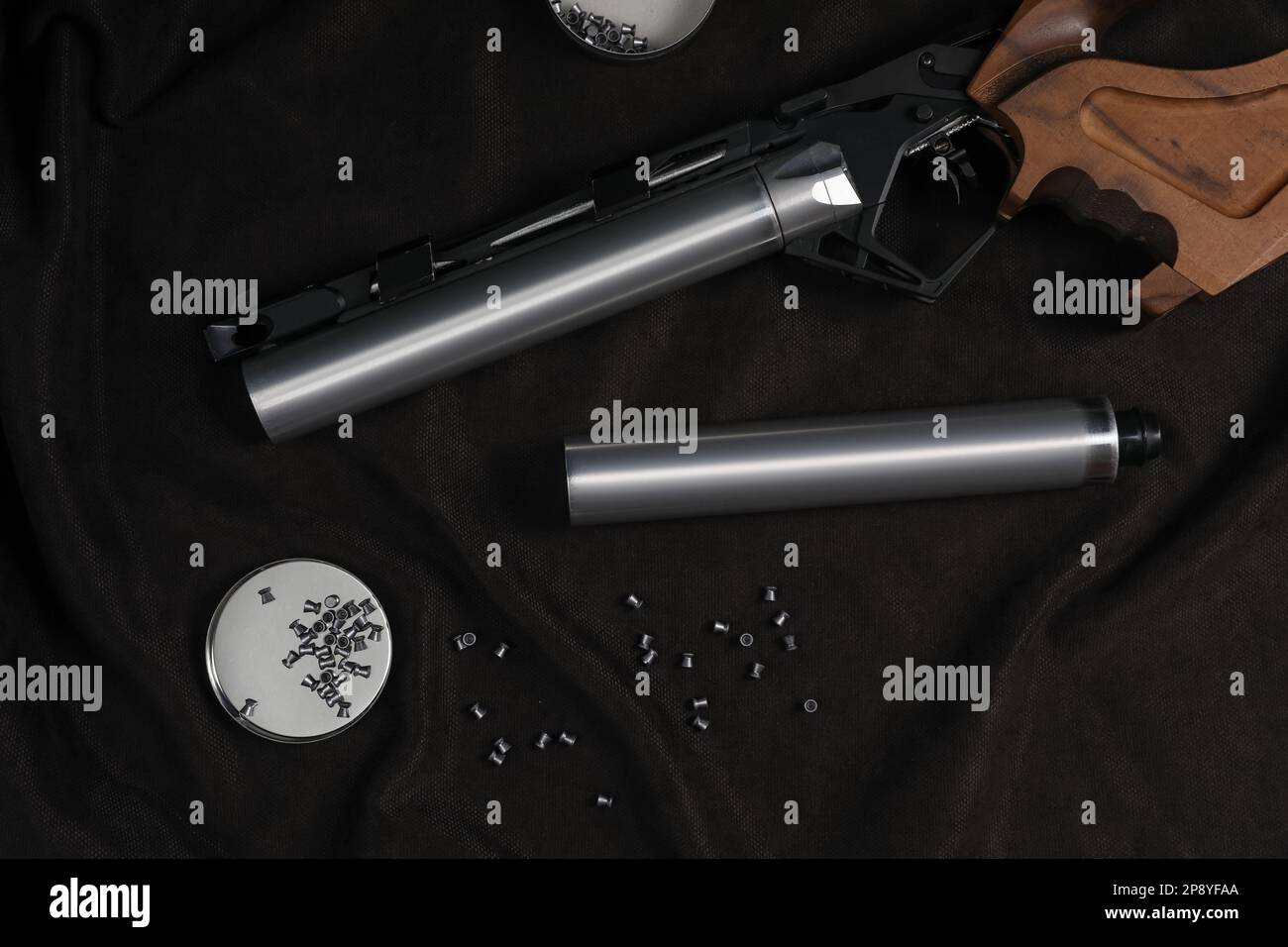 Gun shooting sport. Standard pistol and ammunition on dark fabric, flat ...