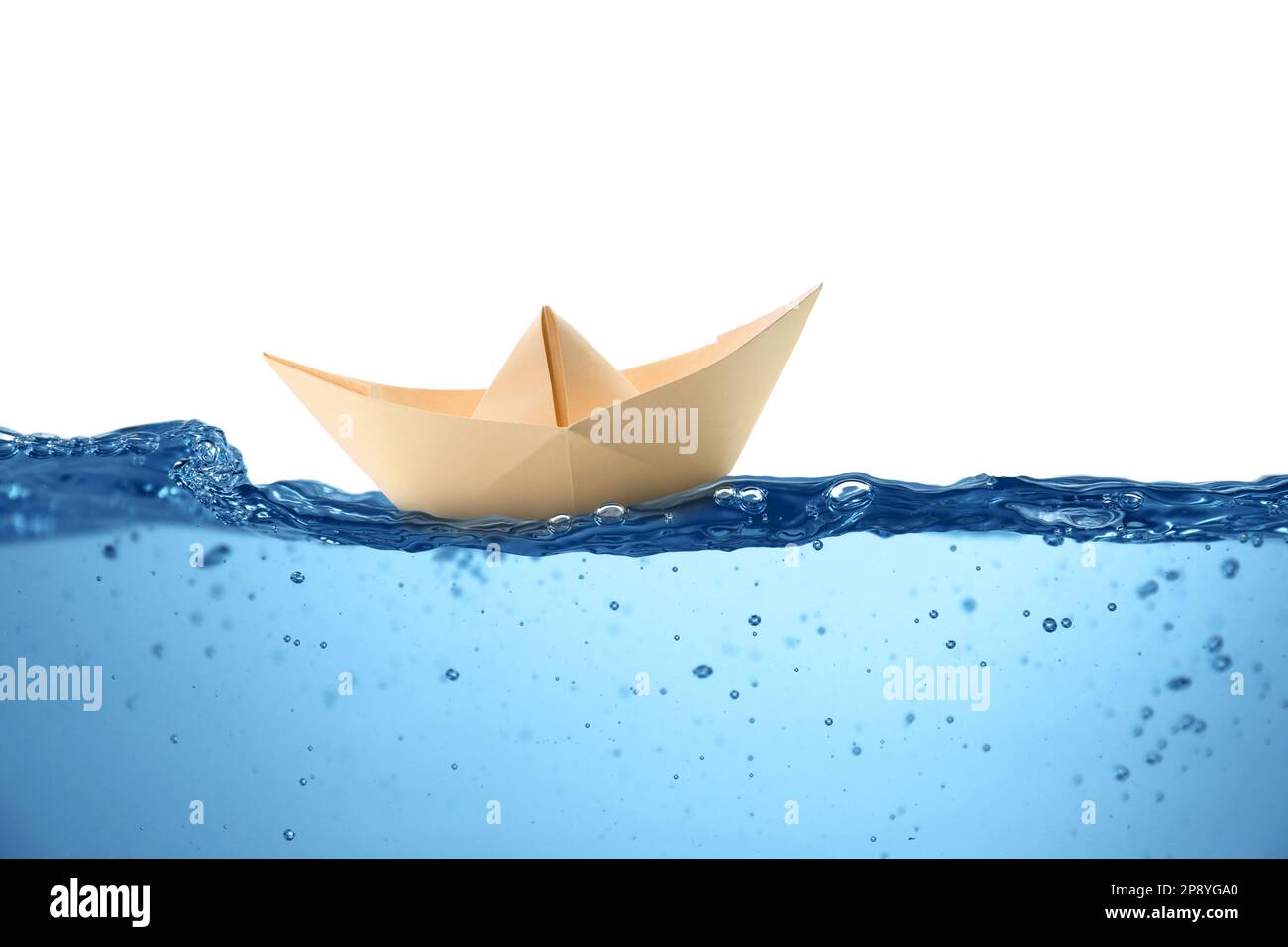 Handmade beige paper boat floating on clear water against white ...