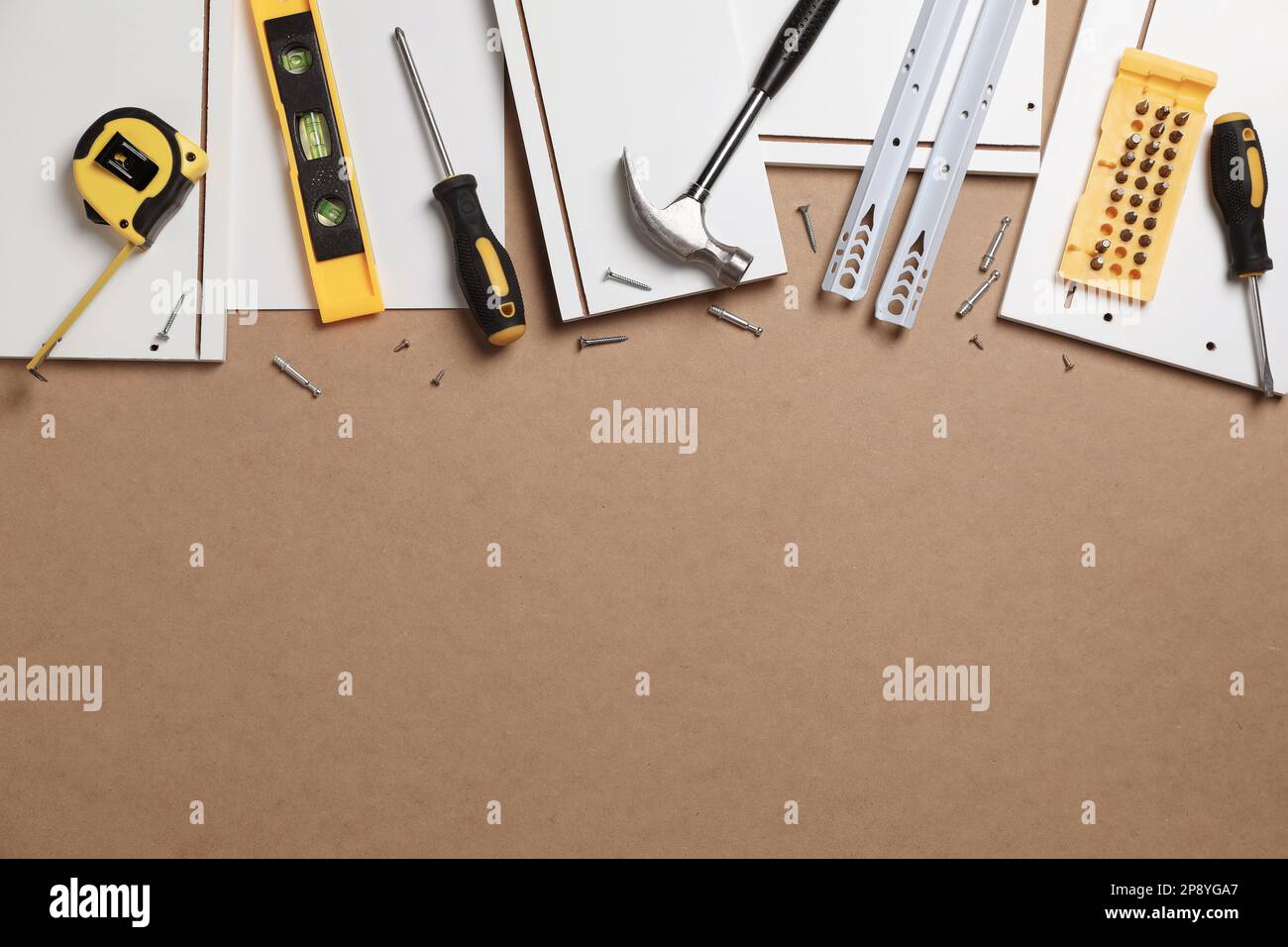 Flat lay composition with furniture assembly parts and tools on brown ...