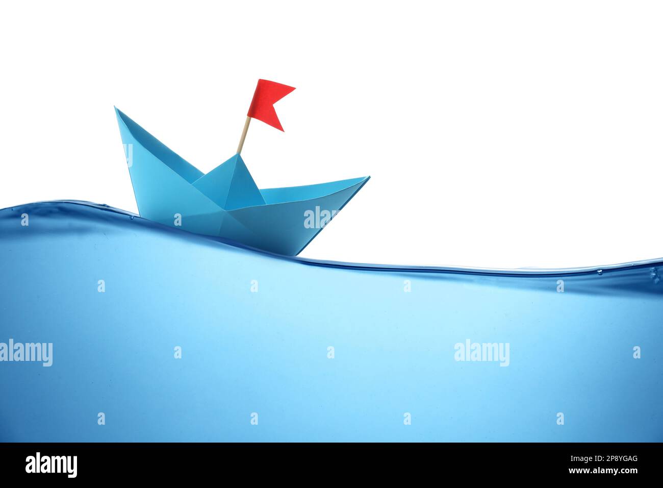 Handmade blue paper boat floating on clear water against white ...