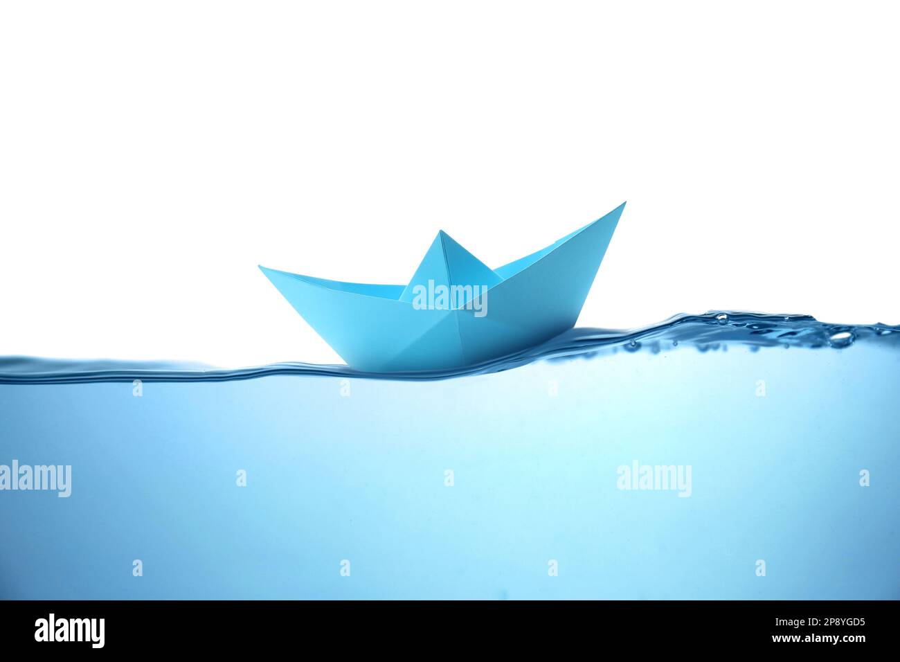Handmade blue paper boat floating on clear water against white ...