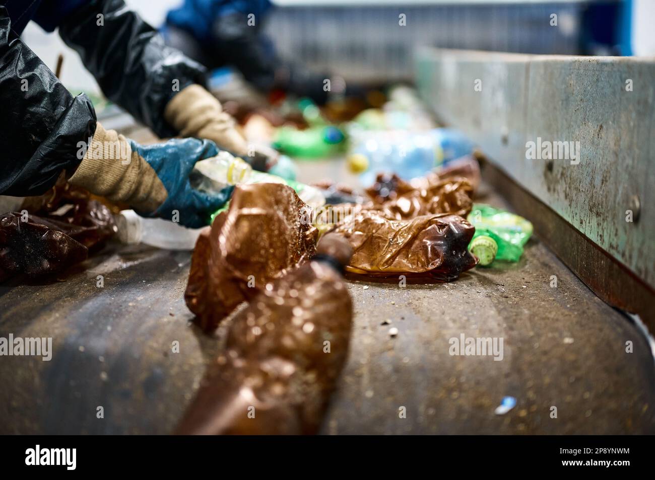 Worker sorts trash on conveyor belt at waste recycling plant Stock Photo - Alamy