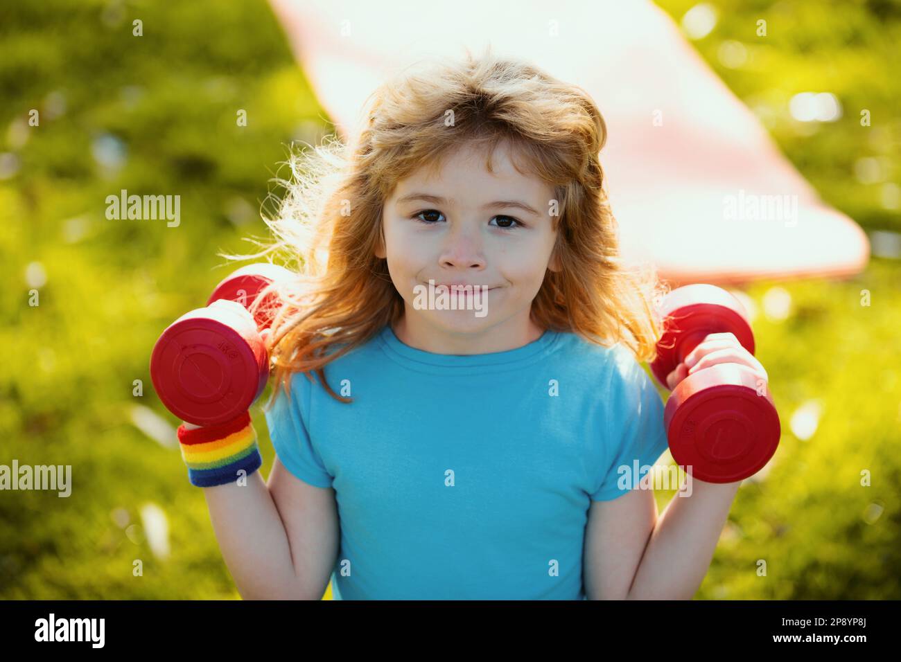Fitness child boy raising a dumbbell. Cute child training with ...