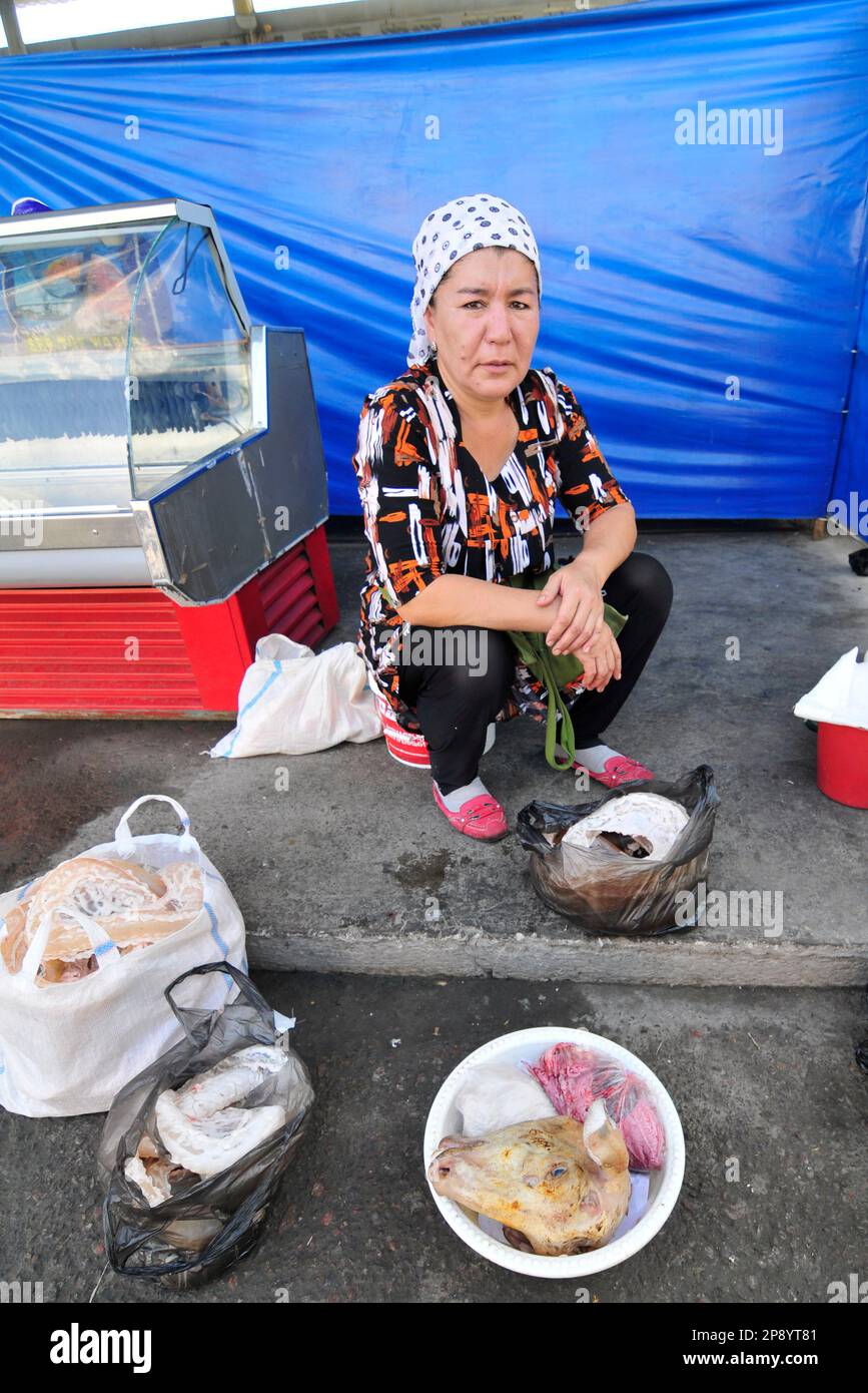 An Uzbek woman selling a Sheep head at the Charsu bazaar in Tashkent ...