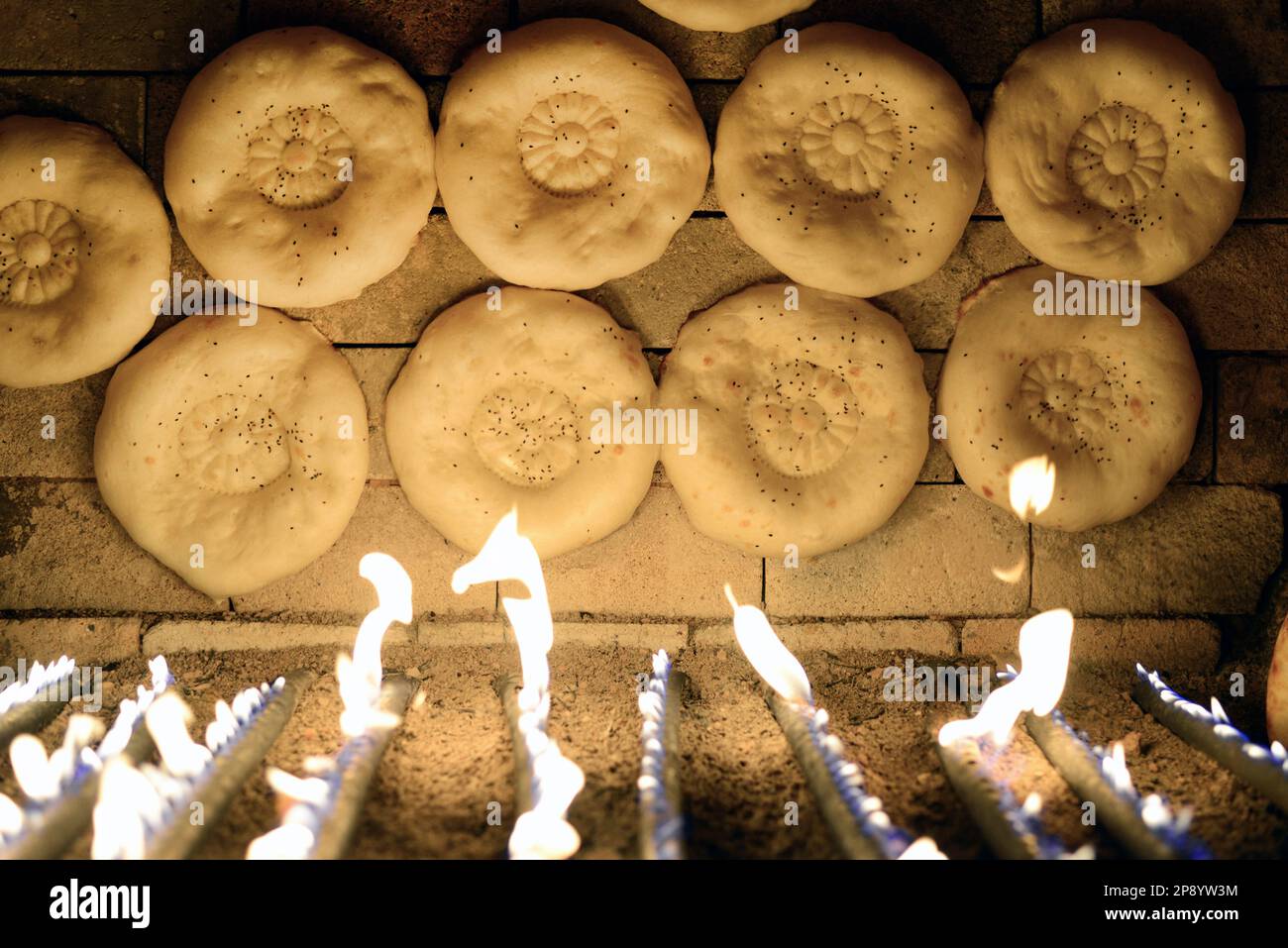 Obi-non bread being baked in a small bakery in the old city of Bukhara ...
