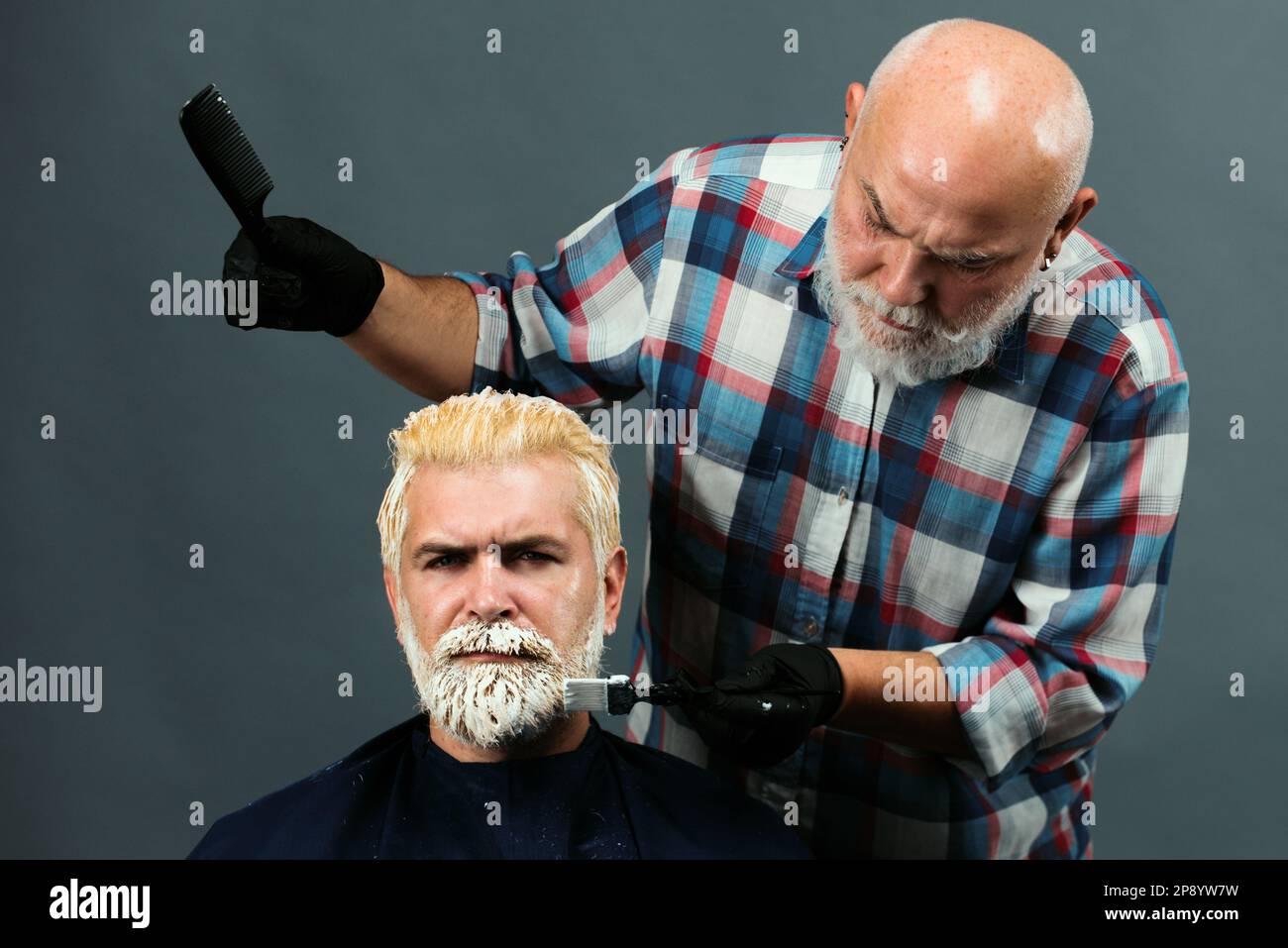 Bearded man coloring hair. Hair salon, hair coloring man. Attractive ...