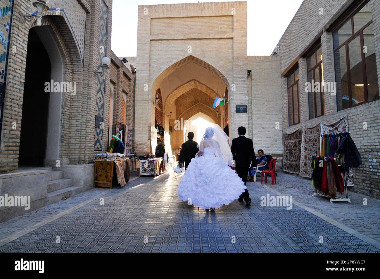 Uzbek newlyweds walk through the old city of Bukhara, Uzbekistan Stock ...