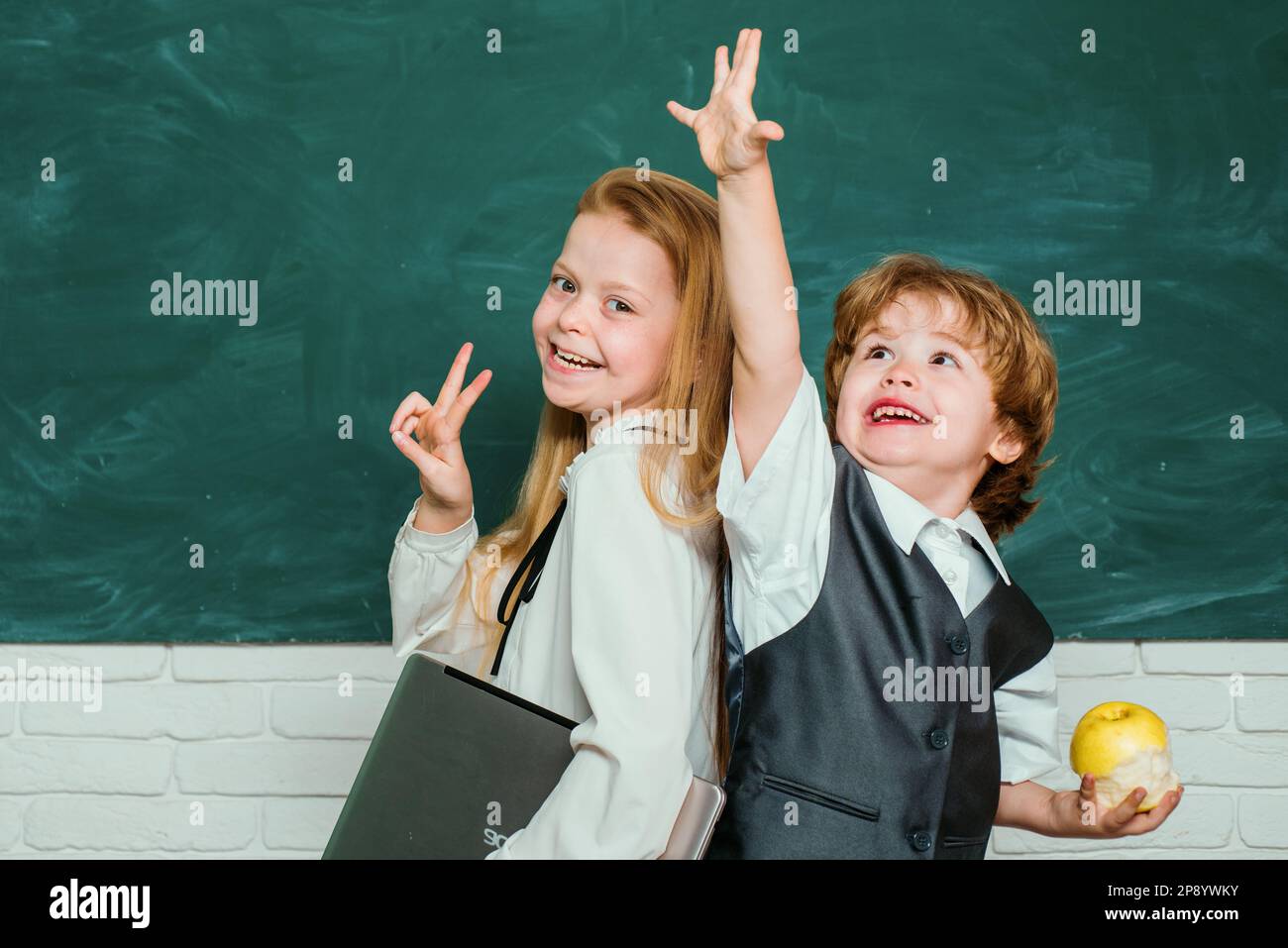 Kids gets ready for school. Couple of little girl and boy in classroom ...
