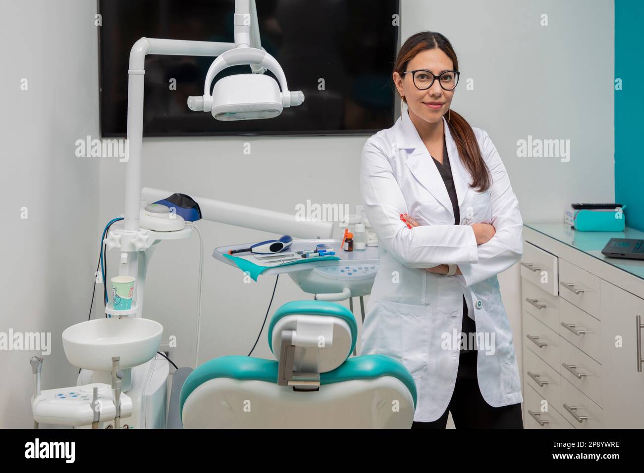 Portrait of a female dentist with arms crossed looking at camera ...