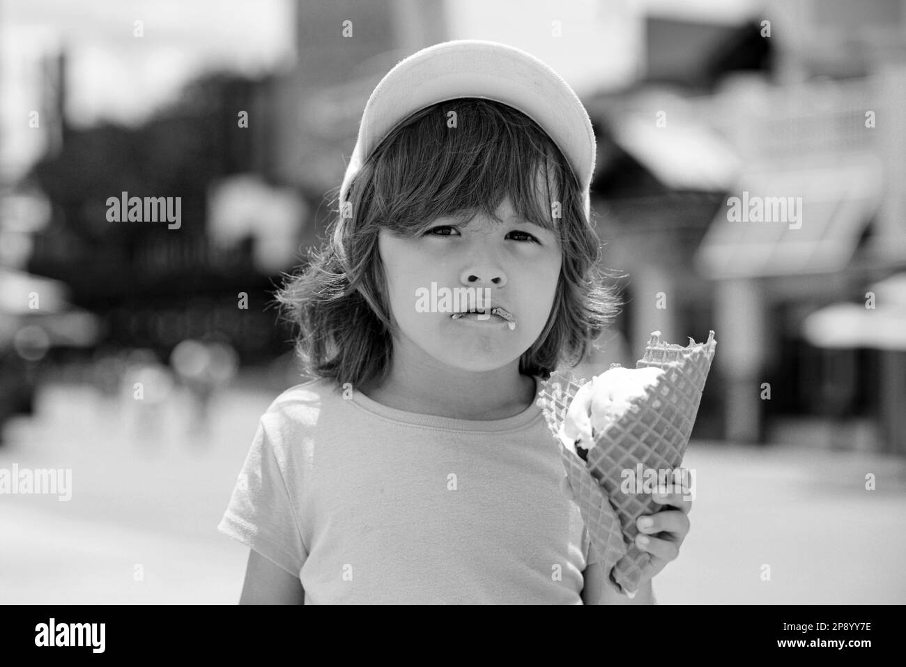 Child eating ice cream. Beautiful little boy eats ice-cream in the ...