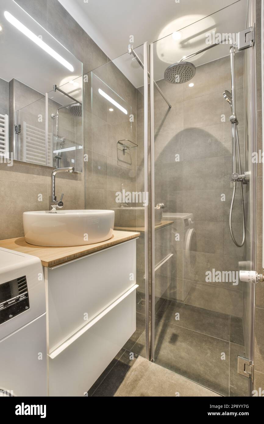 a bathroom with a sink, mirror and shower stall in the corner next to ...