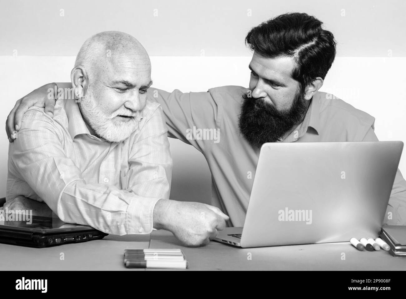 Senior man teaching laptop to his old son. Son and old father using ...