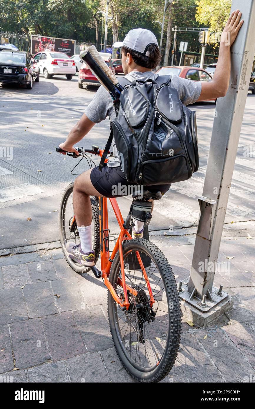Mexico City,waiting to cross busy intersection,backpack tennis racket ...