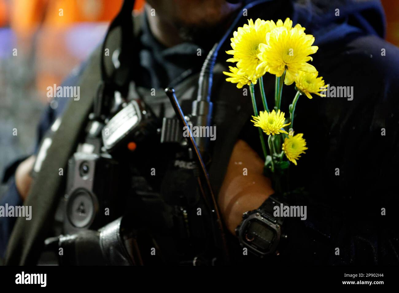 An Atlanta police officer wears flowers on his uniform during a protest ...