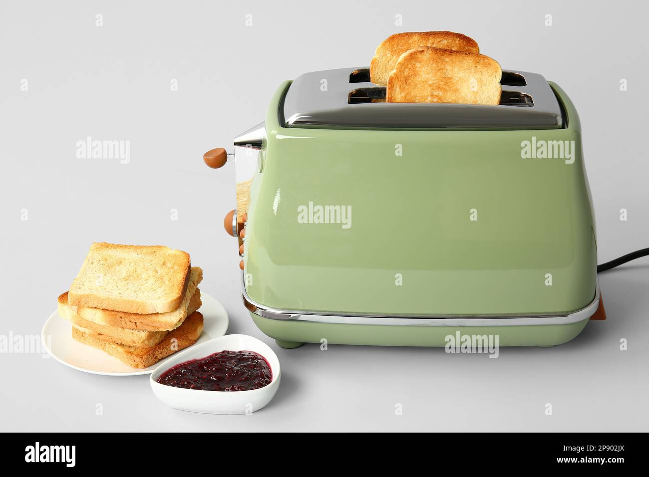 Bread slices in modern toaster, tasty toasts and jam isolated on white background Stock Photo ...