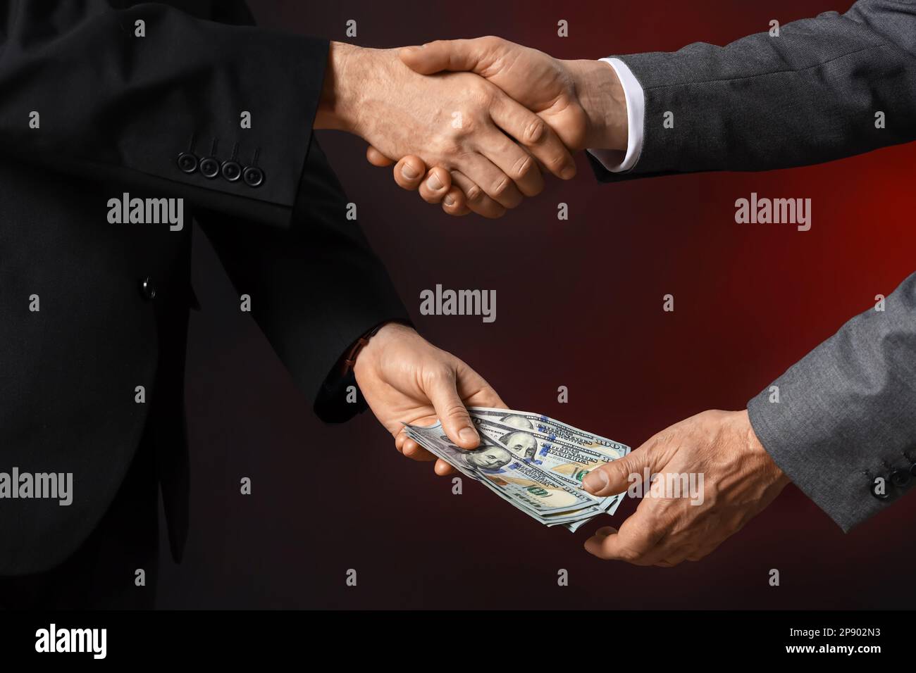 Men with bribe shaking hands on dark background, closeup Stock Photo ...