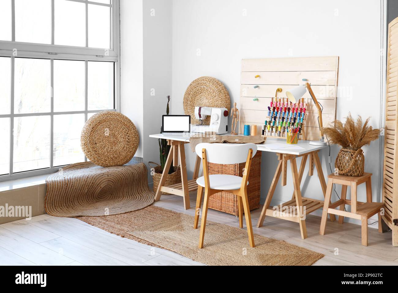 Interior of modern atelier with tailor's workplace and thread spools ...