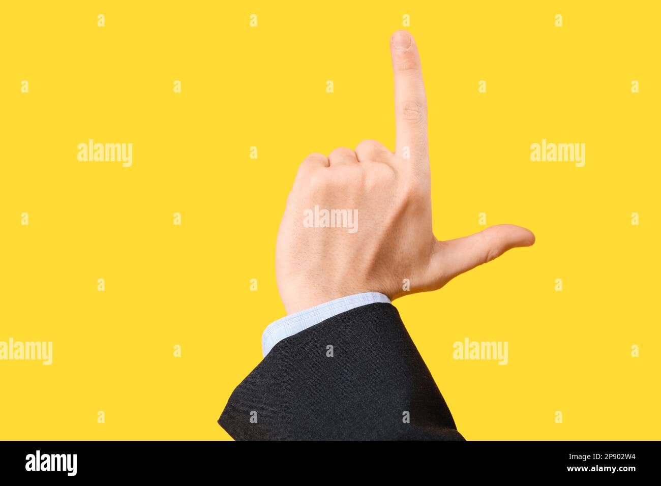 Hand of businessman showing loser gesture on yellow background Stock ...