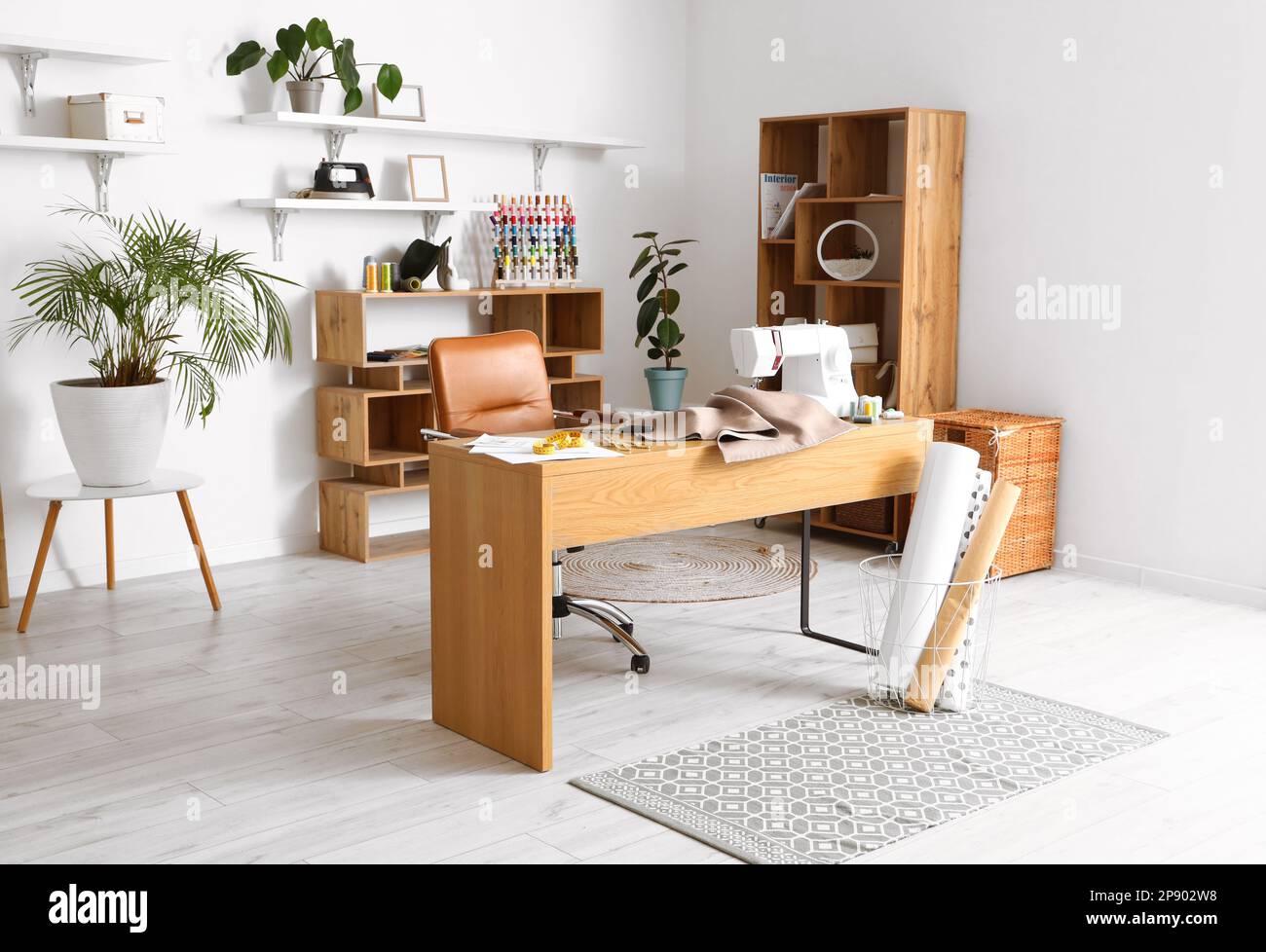 Interior of modern atelier with tailor's workplace and shelving units ...