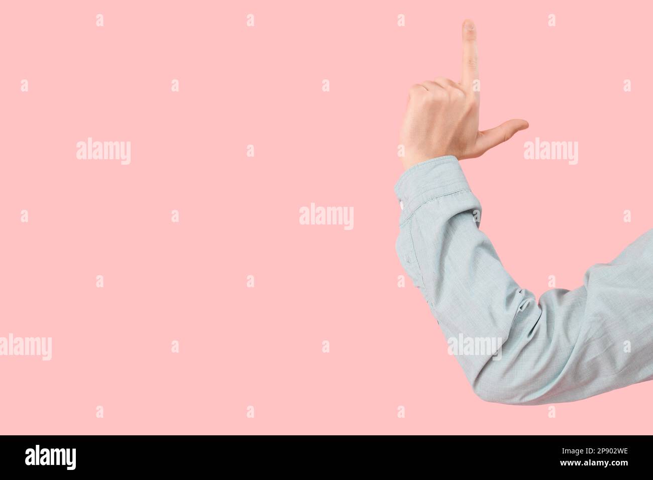 Hand of man showing loser gesture on pink background Stock Photo - Alamy