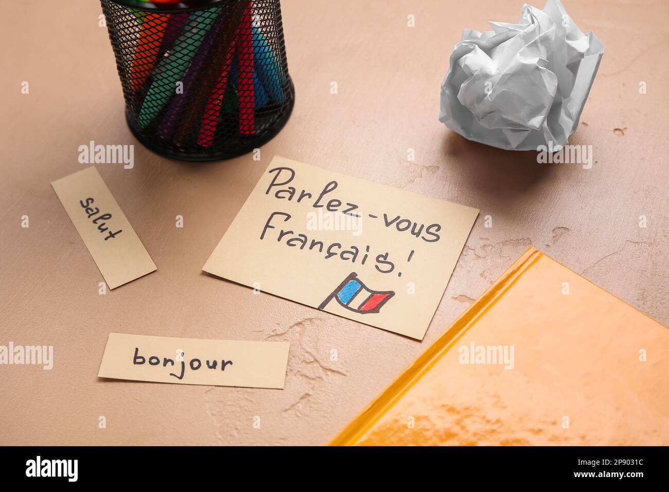 Papers with French words and stationery on beige background, closeup ...