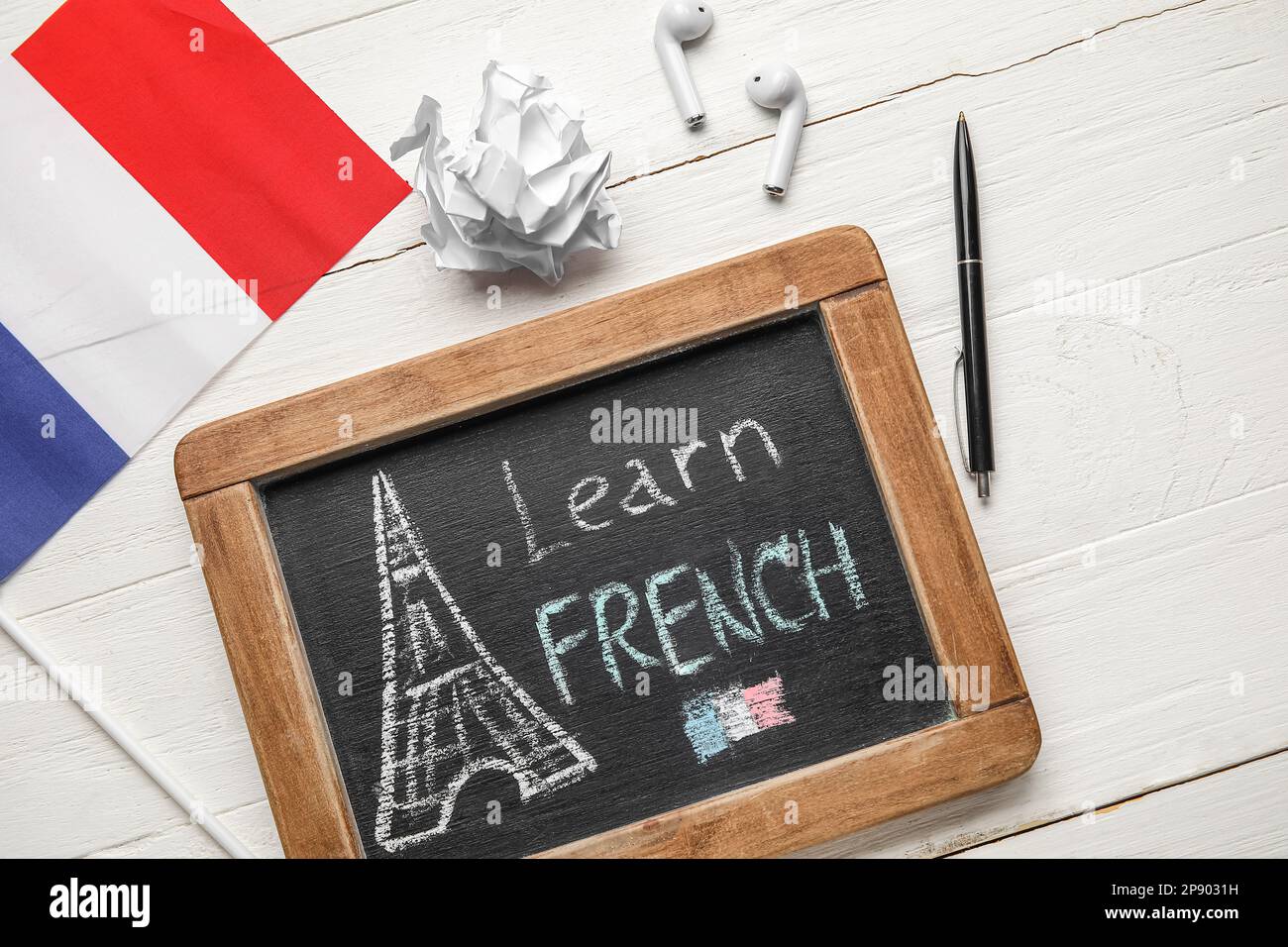 Chalkboard with text LEARN FRENCH, flag, crumpled paper and earphones ...