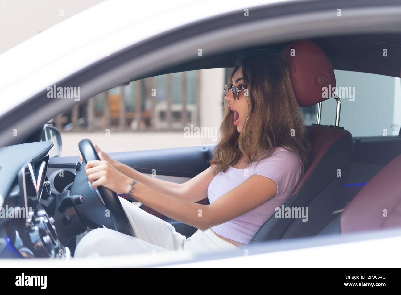 Beautiful young happy smiling woman driving her expensive luxury car ...