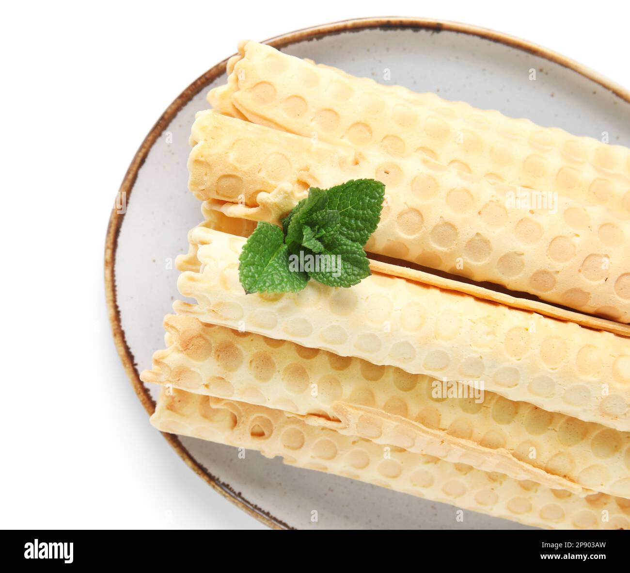 Plate with stack of delicious wafer rolls and mint isolated on white ...