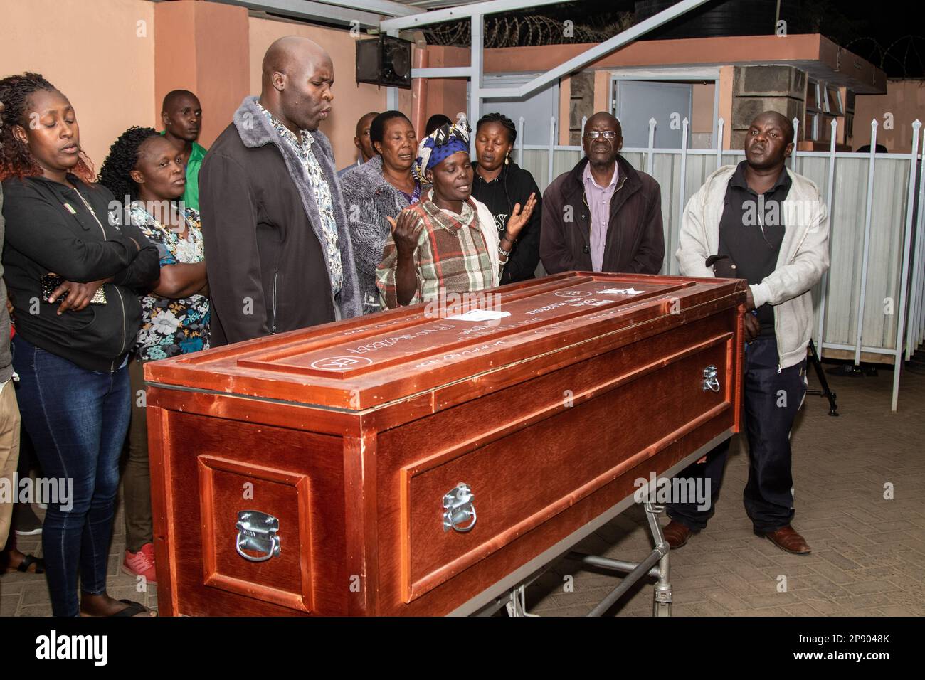 Mourners pray beside the casket containing the body of Judith Adhiambo ...