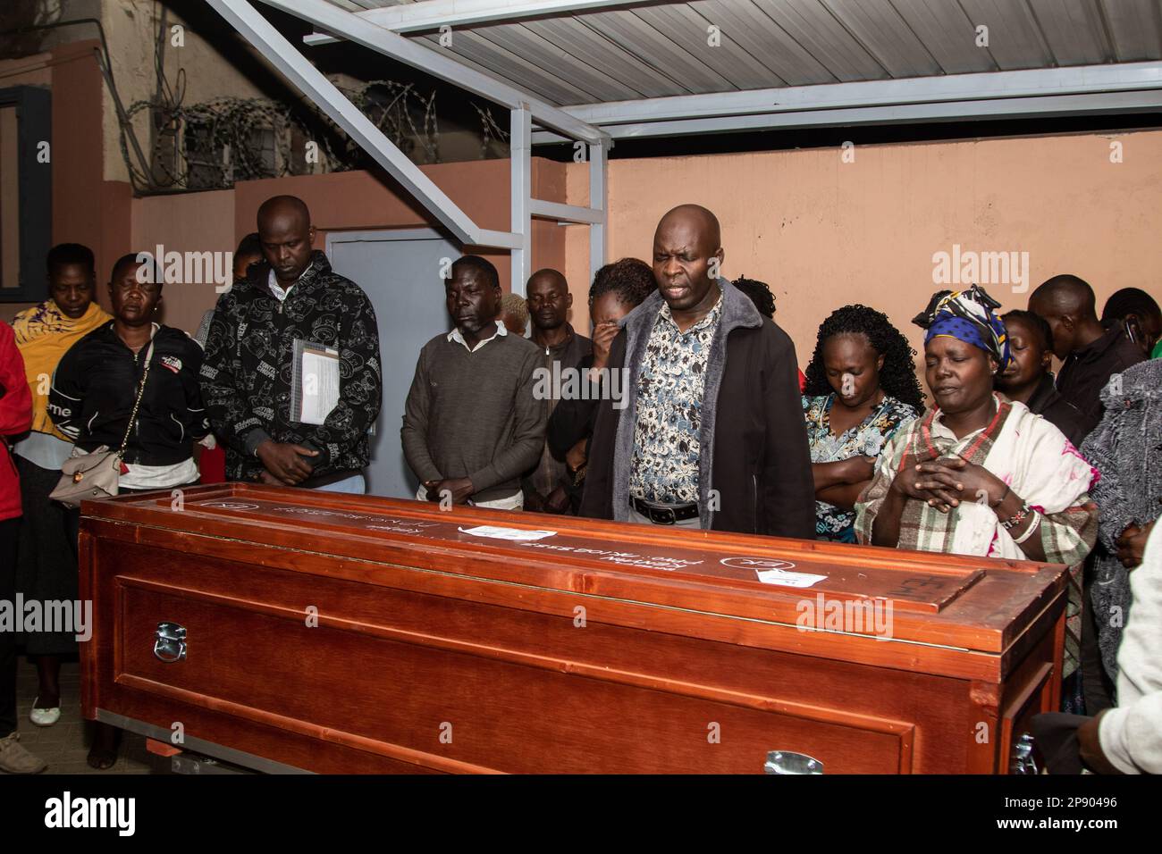 Mourners pray beside the casket containing the body of Judith Adhiambo ...