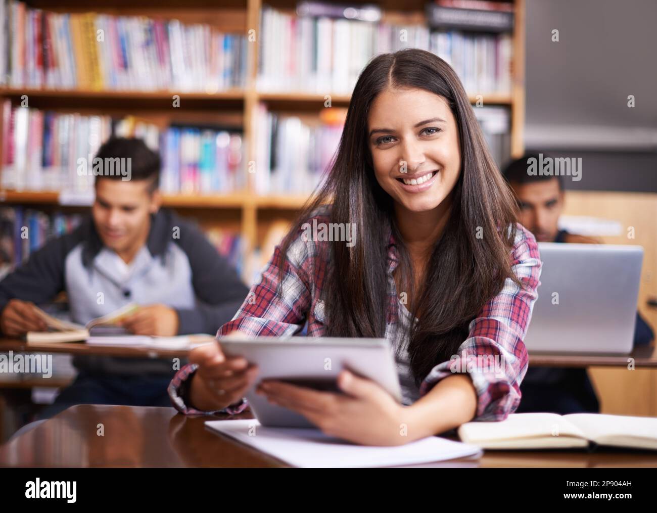 Getting down to some studying. Portrait of an attractive female student ...