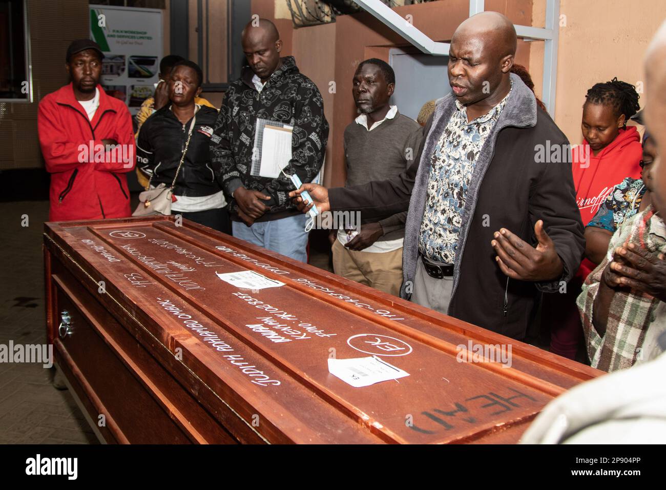 Mourners pray beside the casket containing the body of Judith Adhiambo ...
