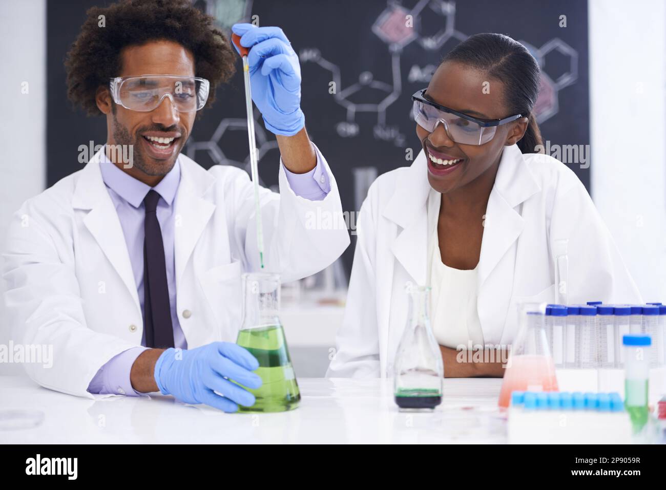 Chemical fun. two scientists conducting an experiment with various ...