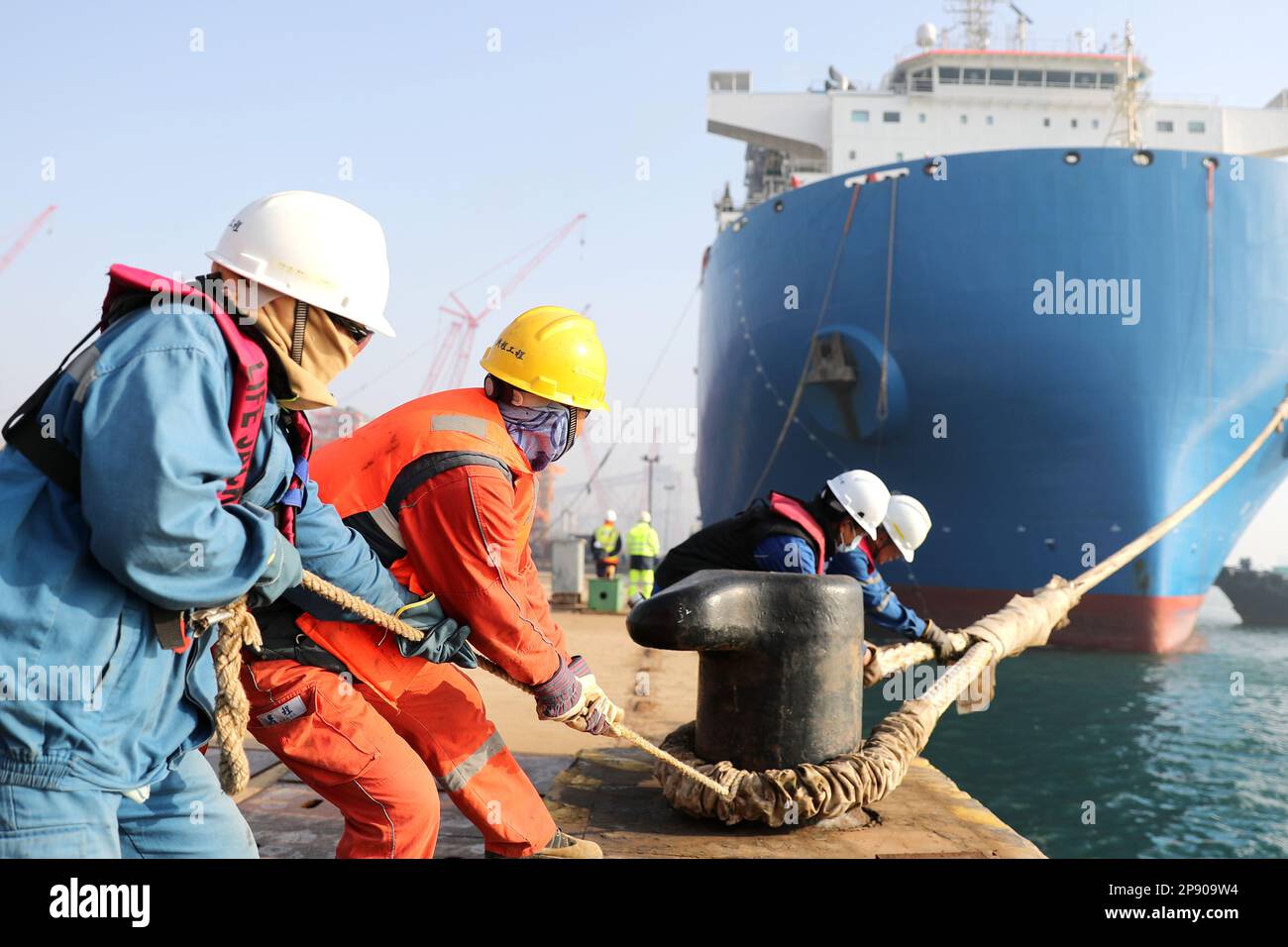 QINGDAO, CHINA - MARCH 10, 2023 - Workers untie the cables of an LNG ...