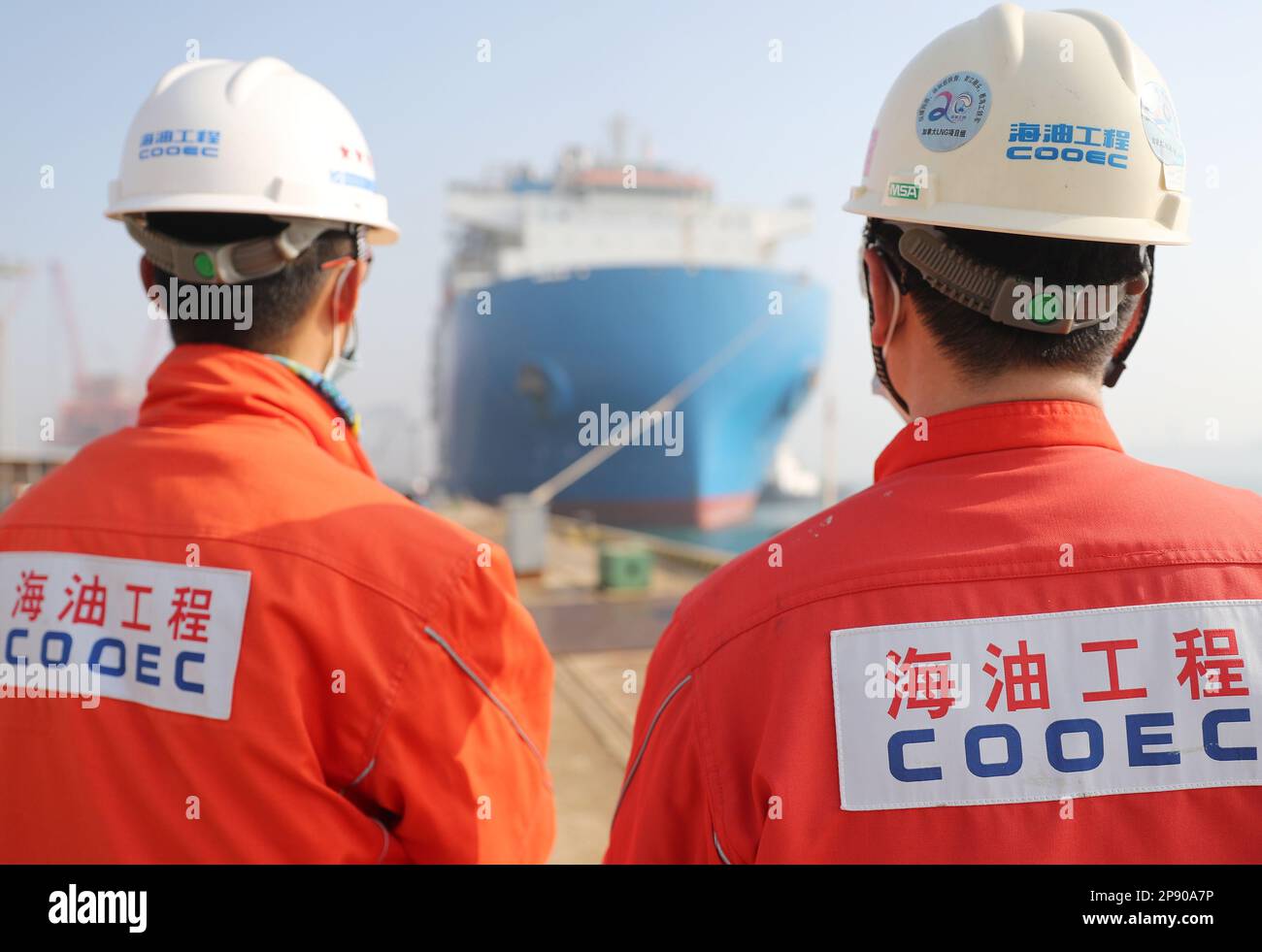 QINGDAO, CHINA - MARCH 10, 2023 - Two dockworkers watch as an LNG ...