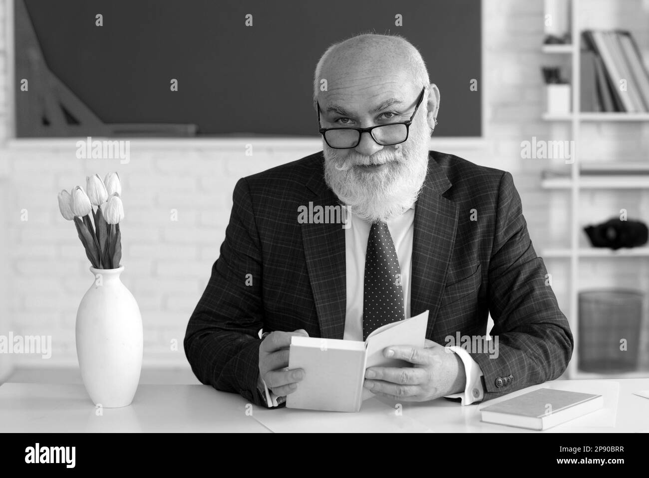 Grey hair professor in empty lecture classroom. School teacher or ...