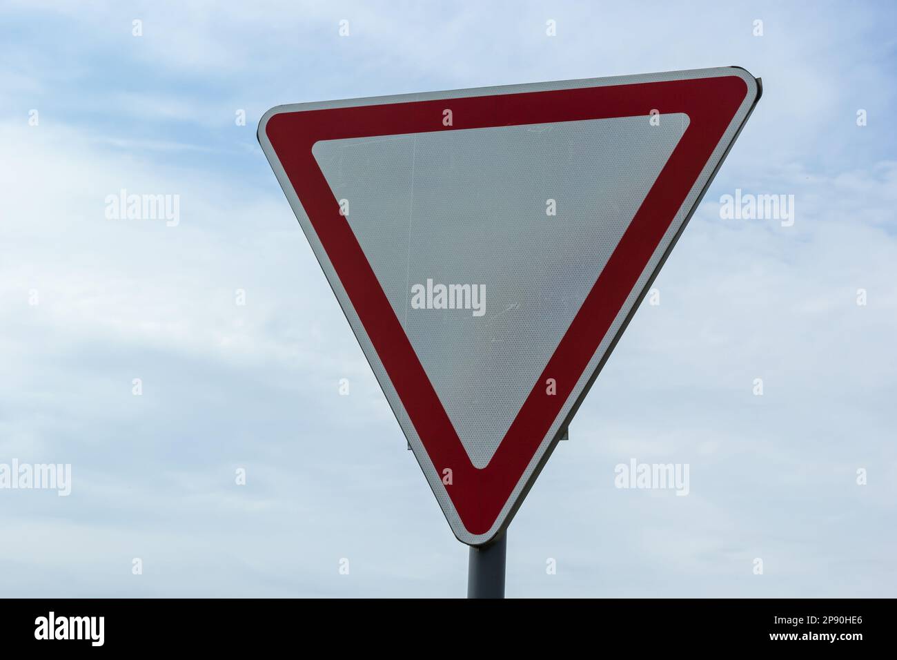 Road sign against the sky. White triangle with red border. Signal, Give ...